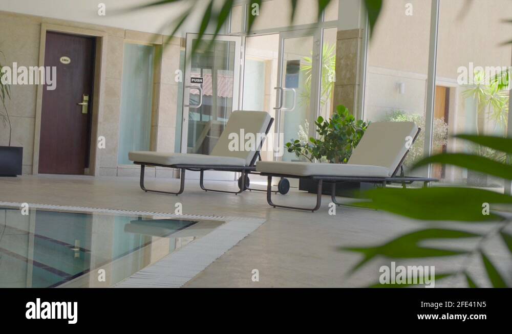 Indoor pool inside a luxurious Villa with shezlong chair with plants ...