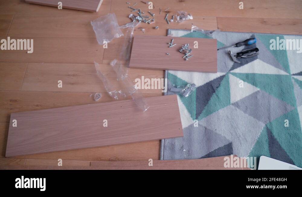 Messy disassembled furniture parts on the ground carpet inside the ...