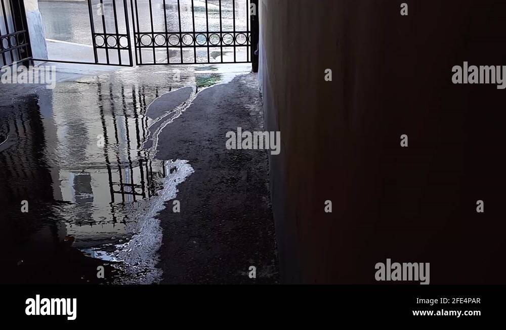Raining. Wet street with reflections of walking people. Looking through ...