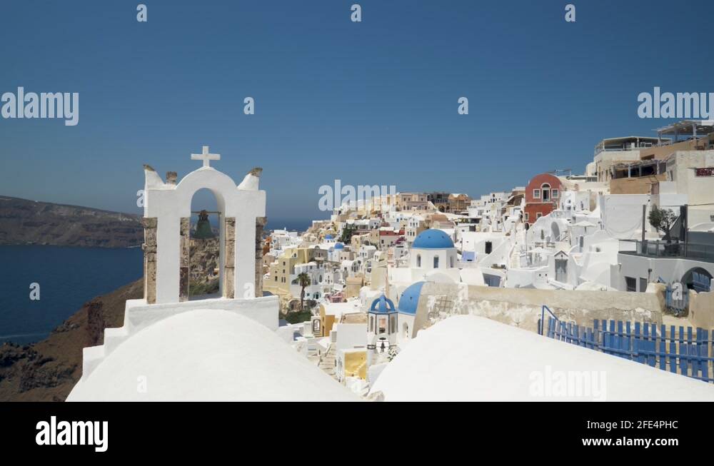 Sideways pan, white houses and blue dome churches in Santorini, Greece ...