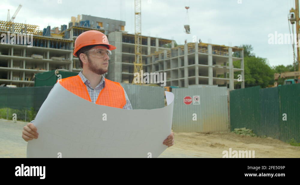 Architect man walking on the construction site and analyzing scheme ...