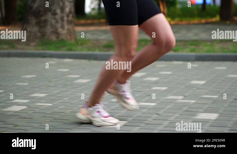 Female athlete's feet running at the park. Fitness woman jogging ...