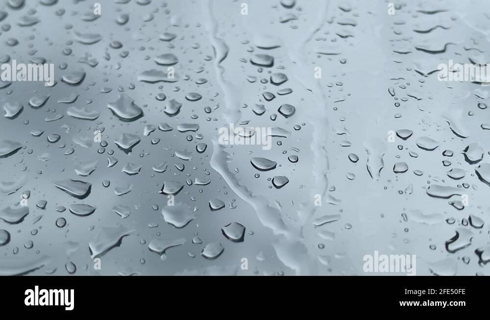 Wet glass window from rain water from the precipitation of a dark storm ...