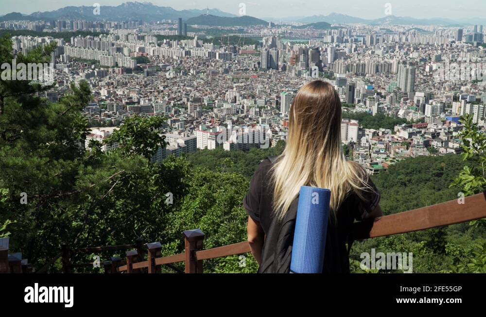 Back view of blond girl spreading arms up and creating a heart shape ...