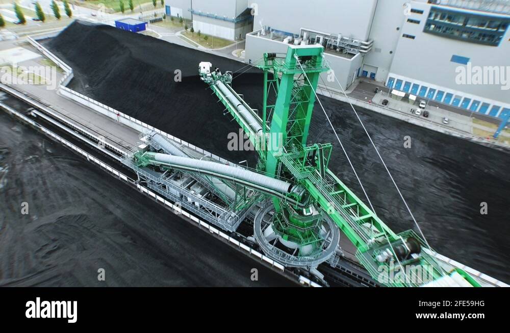 Fly by with drone at a coal power plant with massive digger machine ...