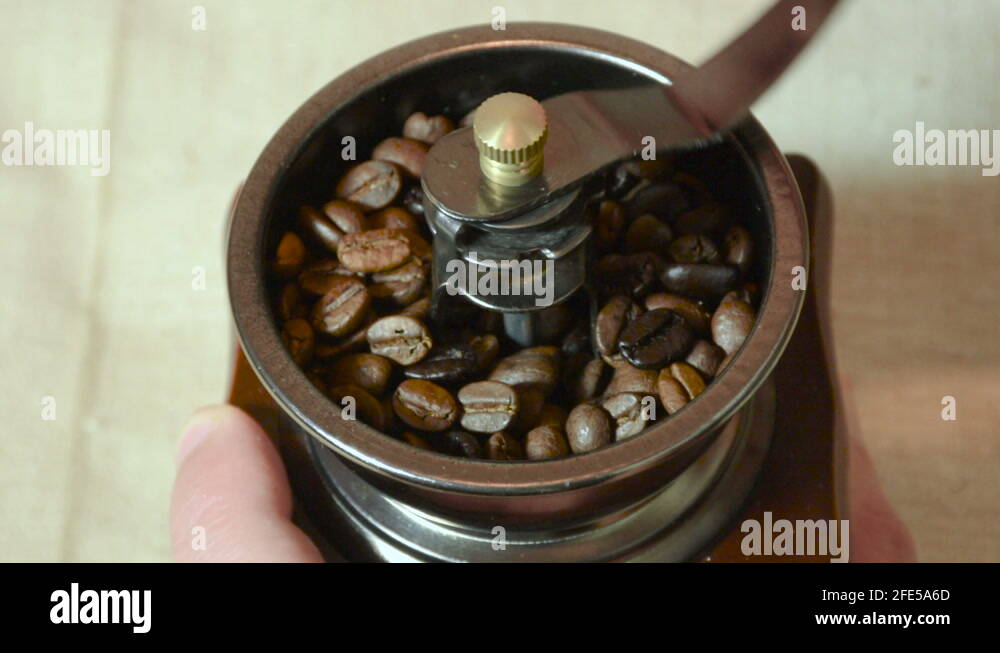 Man hand grinding roasted coffee in old retro mill. Prepare coffee on ...