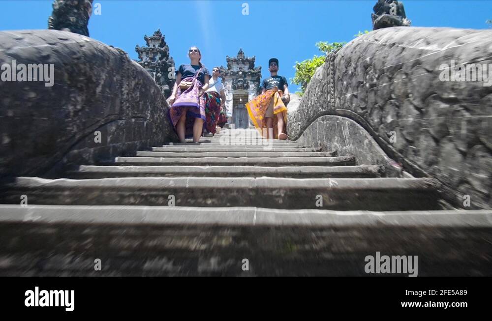 Travellers pose on the steps of a religious temple in Bali, Indonesia ...