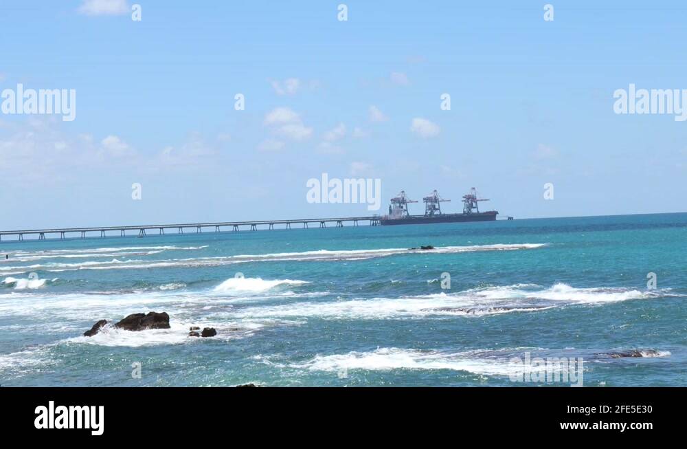 The Mediterranean sea waves with a bridge connected to the power plant ...