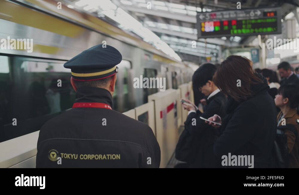Japanese Train Staff Standing On The Platform With Passengers On The ...