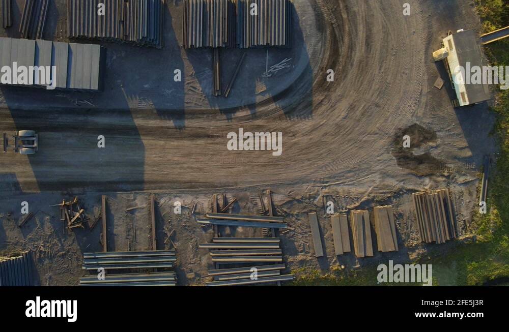 Magnet equipped tracked loader at a steel mill loads a truck trailer ...