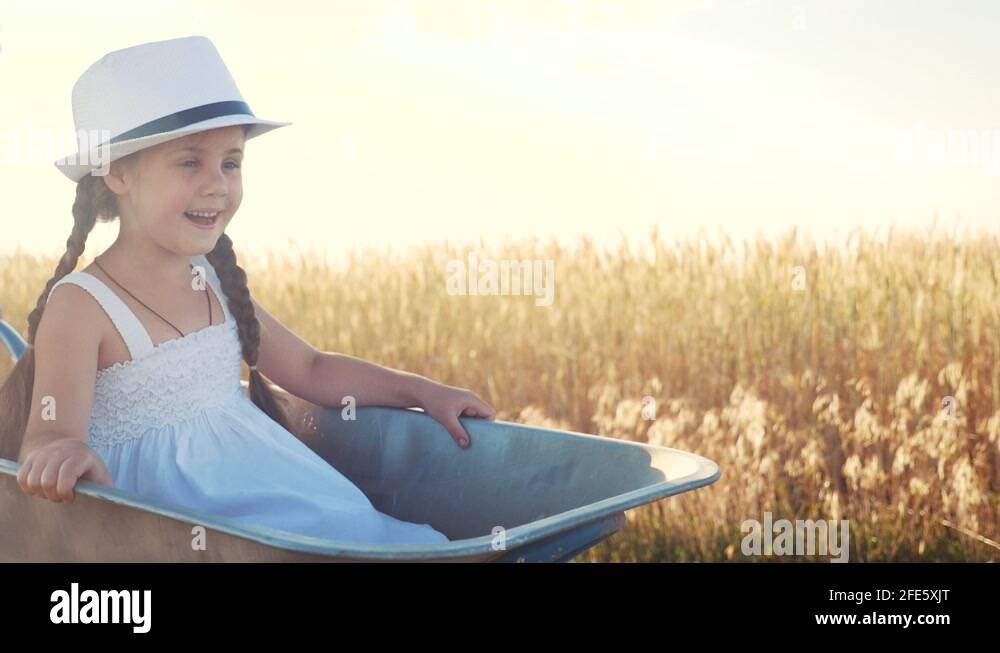 kid children play with a garden trolley car ride on wheelbarrow. little ...