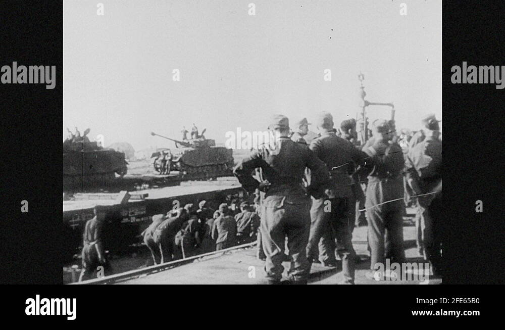 1940s Germany: Soldiers by train carrying tanks. Soldiers sitting on ...