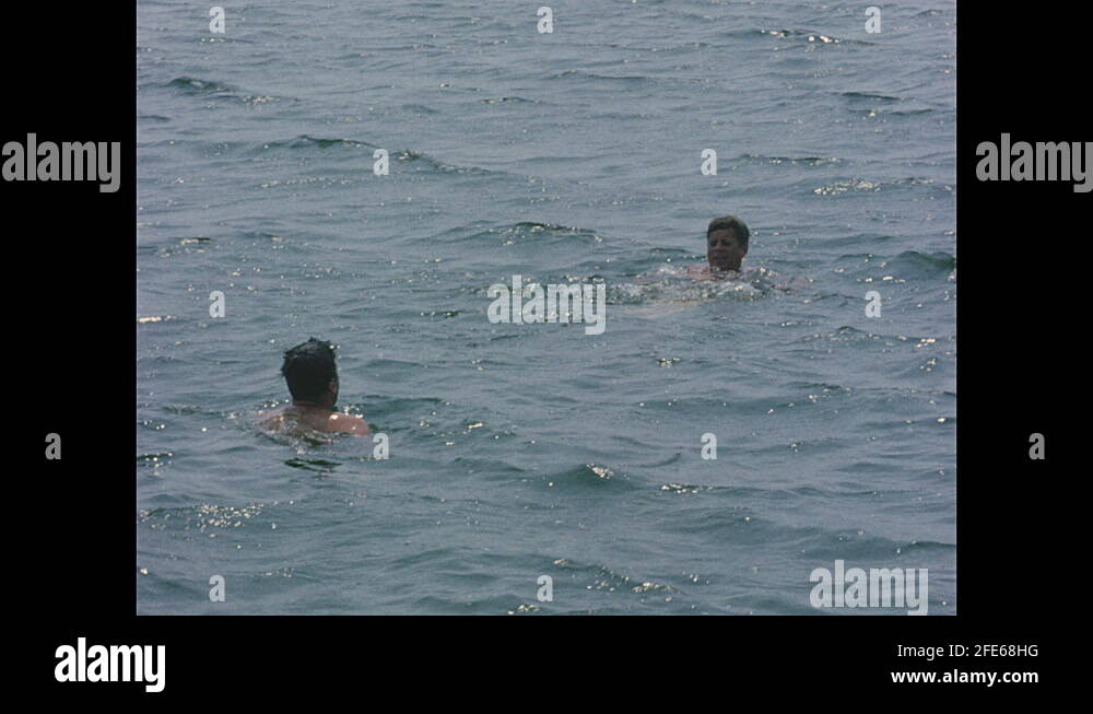 1960s: John F Kennedy and Peter Lawford swimming, pan to Paul Fay ...