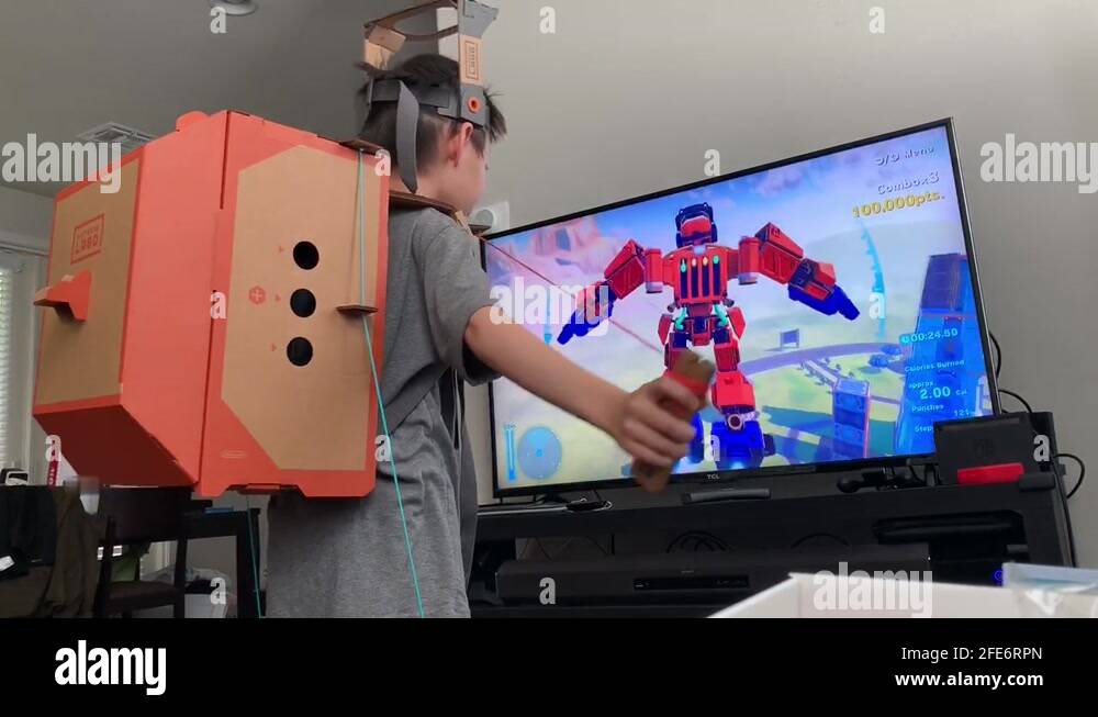 Boy wearing a cardboard Nintendo Labo Robot suit and playing Augmented ...