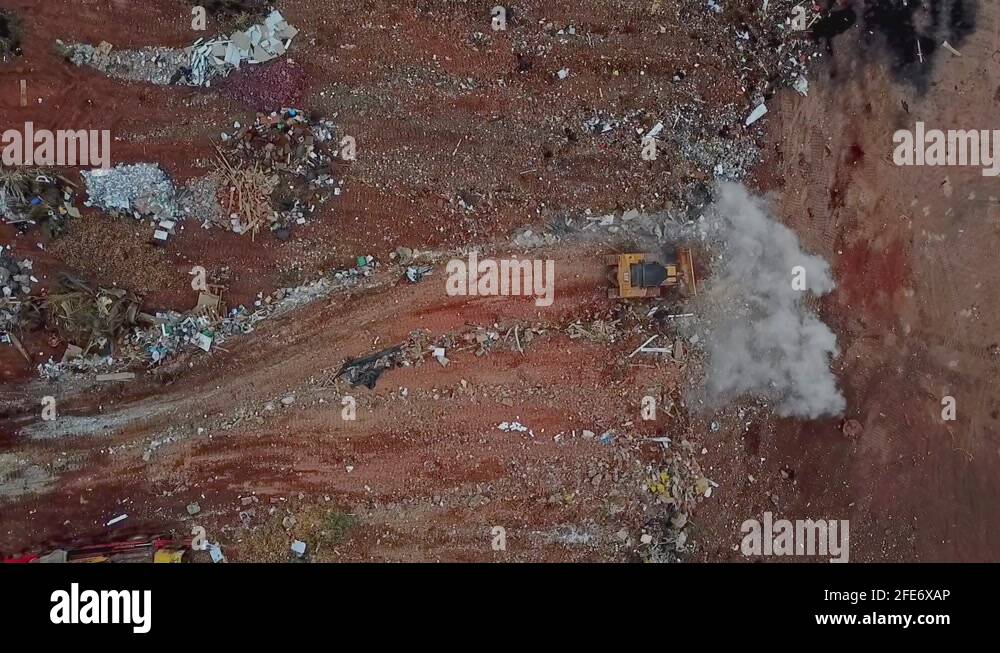 bulldozer operating on landfill. Waste compaction process. Birds eye ...
