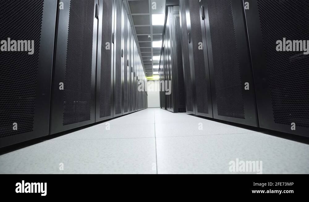 Floor level tracking shot. Long isle of server racks at data center ...