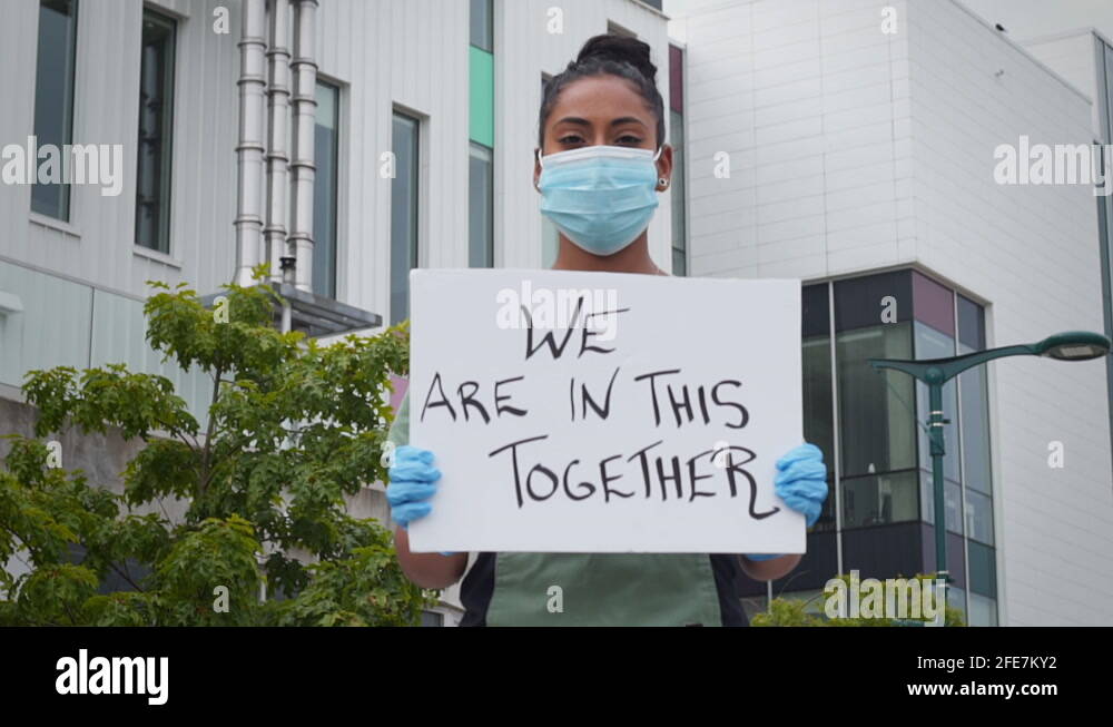 Indian woman, POC, nurse wearing PPE uniform, stands in front of ...