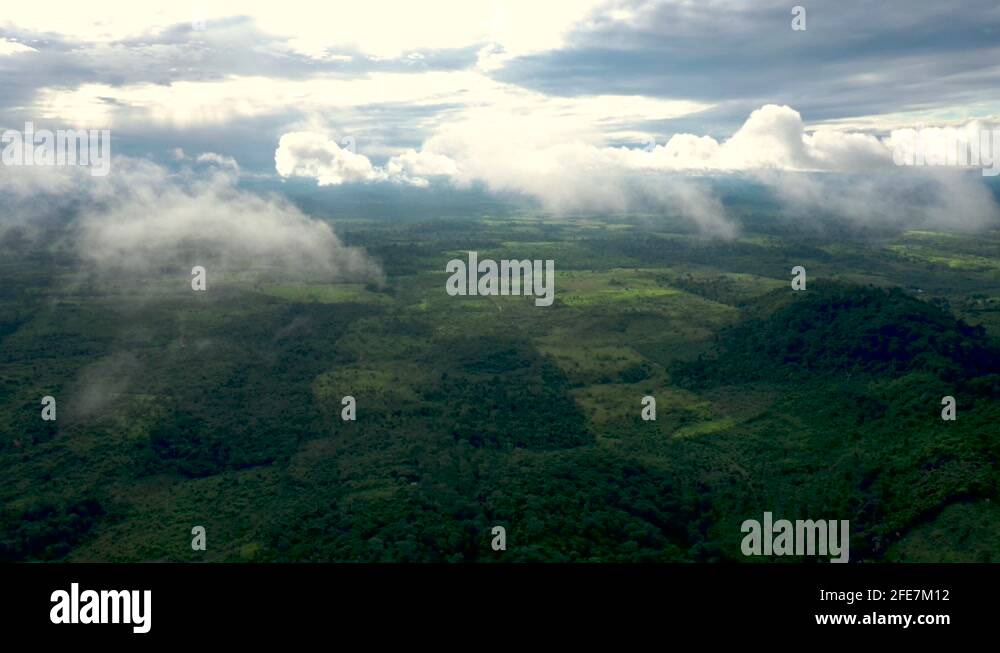 Flying through the clouds above a degraded area of the amazon ...