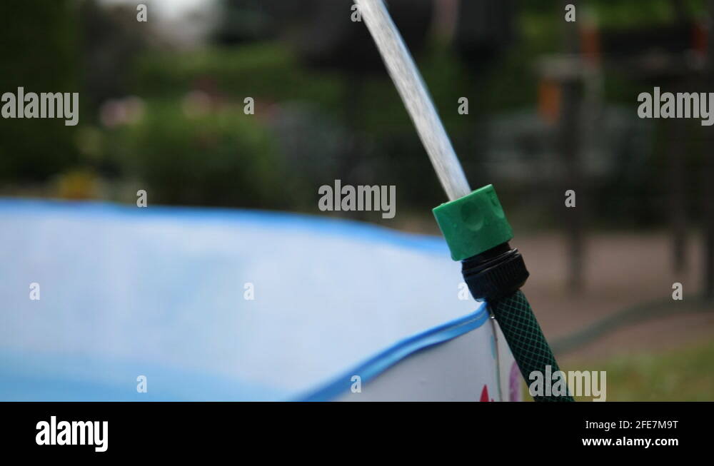 Flexible hose pump water green pipe. Filling up swimming kids children ...