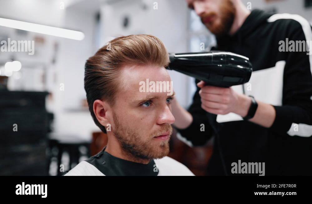 Barber performs haircuts and hair styling. New trends in men's haircuts ...