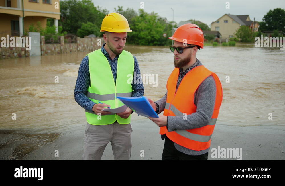 Two male engineers solve the flood problem. Natural disaster major ...