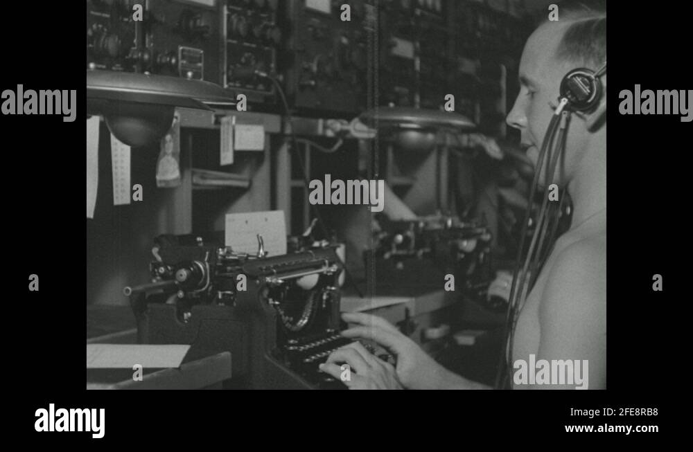 1940s: Shirtless naval sailor types on typewriter listening to ...