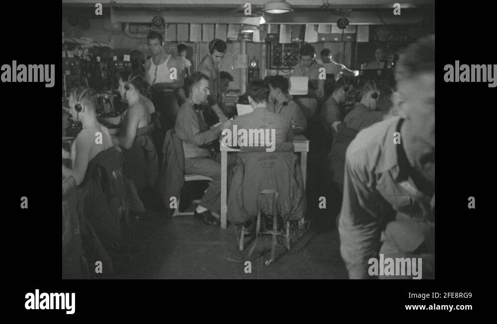 1940s: Group of sailors and radio operators below deck. Shirtless radio ...