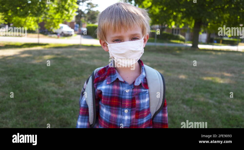 Little boy takes off his face mask in a school yard Stock Video Footage ...