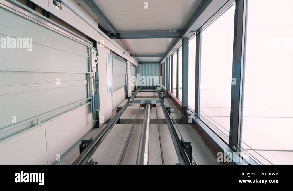 Elevator lift cabines up inside illuminated elevator shaft with ...
