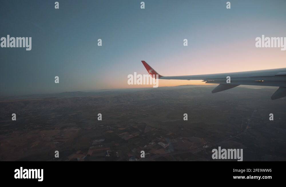 Airplane window view of the planes left wing while taking a turn ...