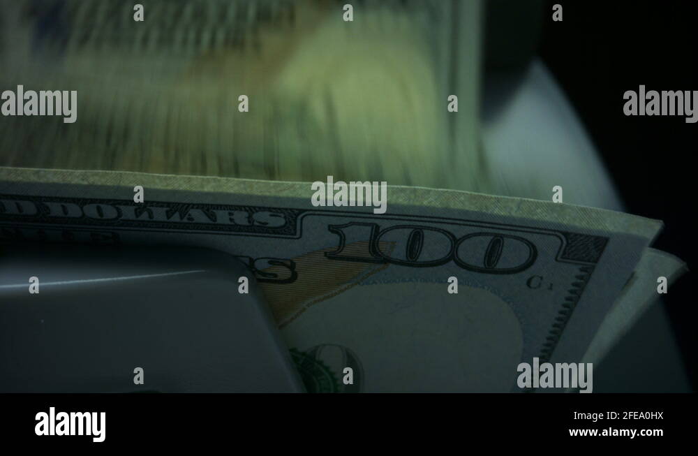 Counter counting dollar bills. Money counting machine with 100 dollar ...