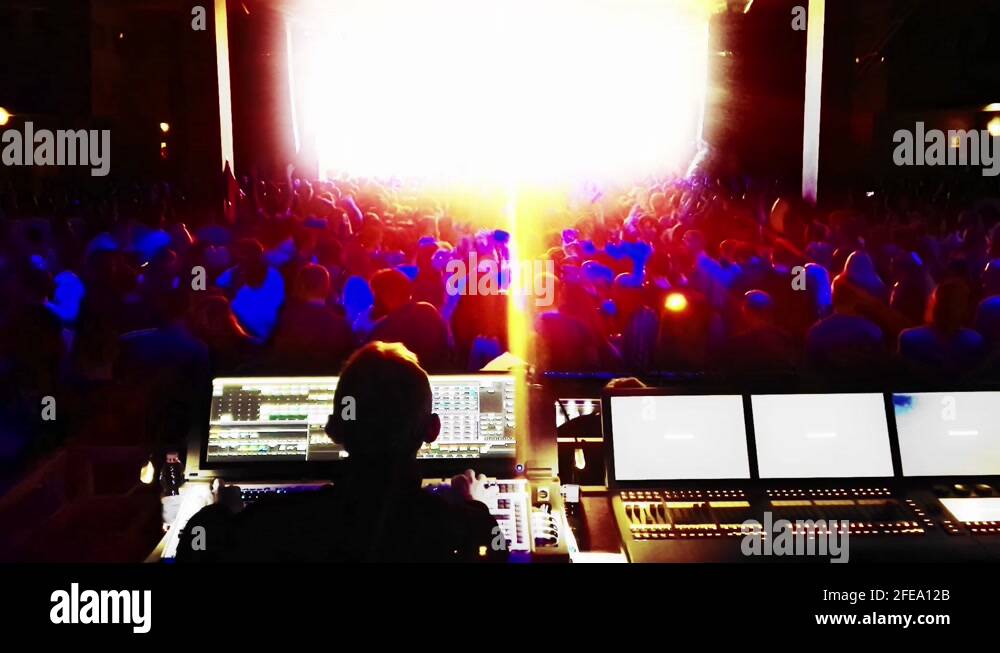Man in backstage control room managing live concert, people cheering on ...