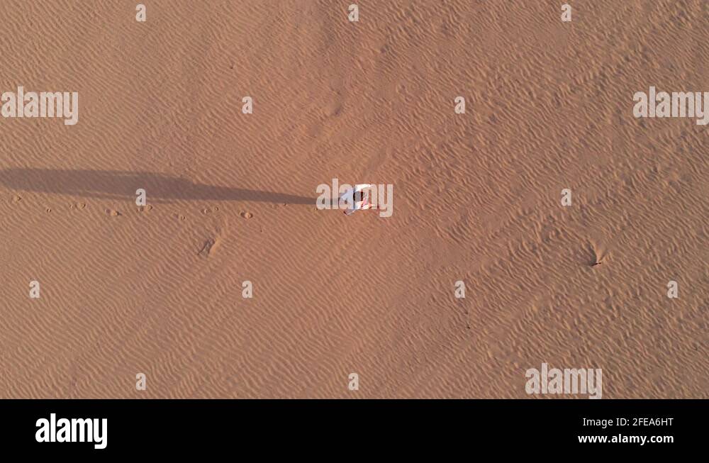 Overhead Aerial of Girl Walking in Desert at Golden Hour, Footprints ...