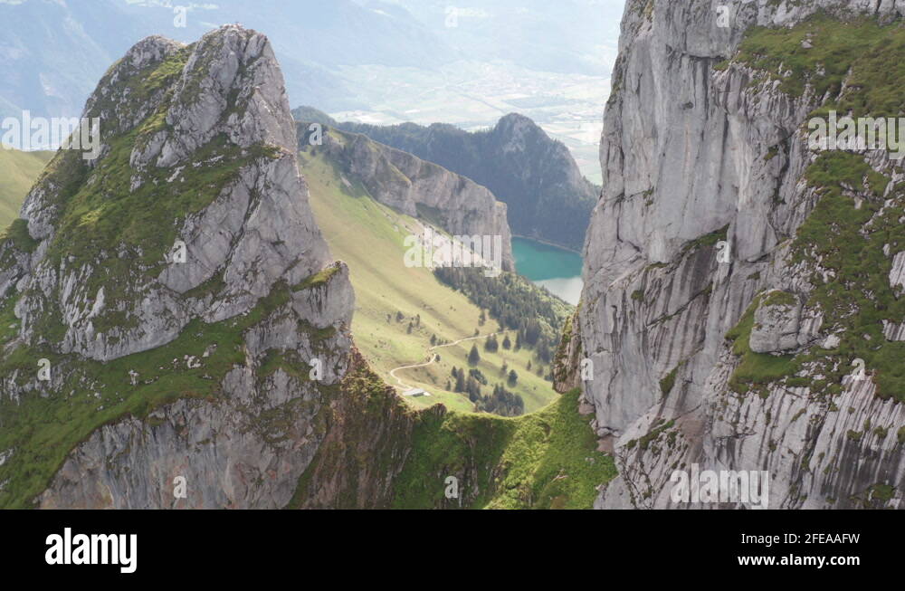 Flying past high mountain top, revealing a beautiful valley with a ...