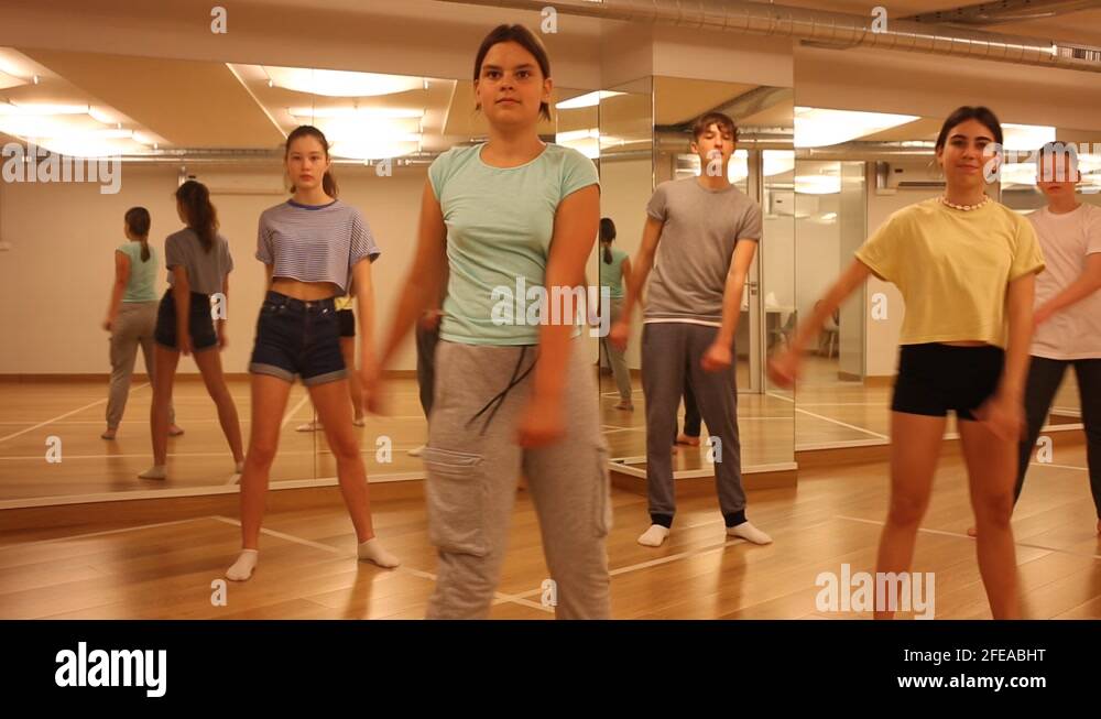 Teenage boys and girls practicing floss dance movements, swinging hips ...