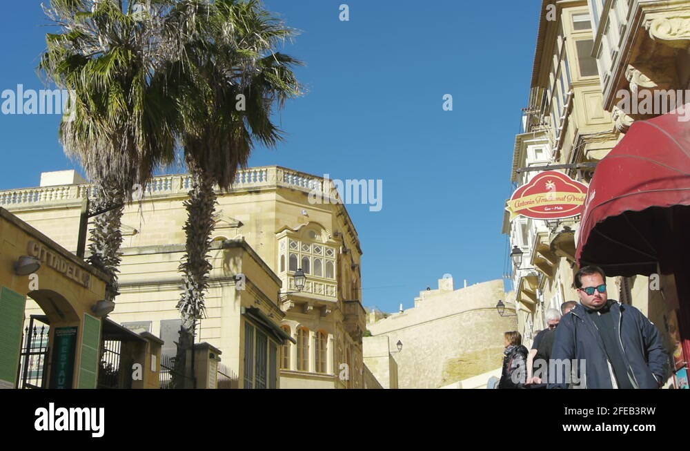 Local crowd of people walking the interior streets of Gozo in Malta ...