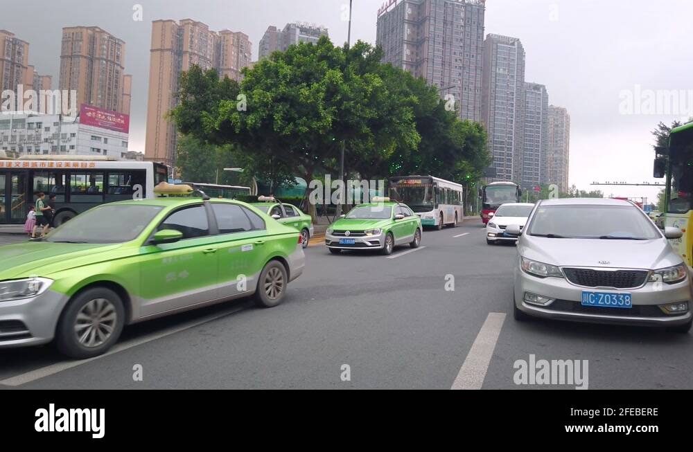 Car front view of the green bus, taxis and traffic on busy street in ...