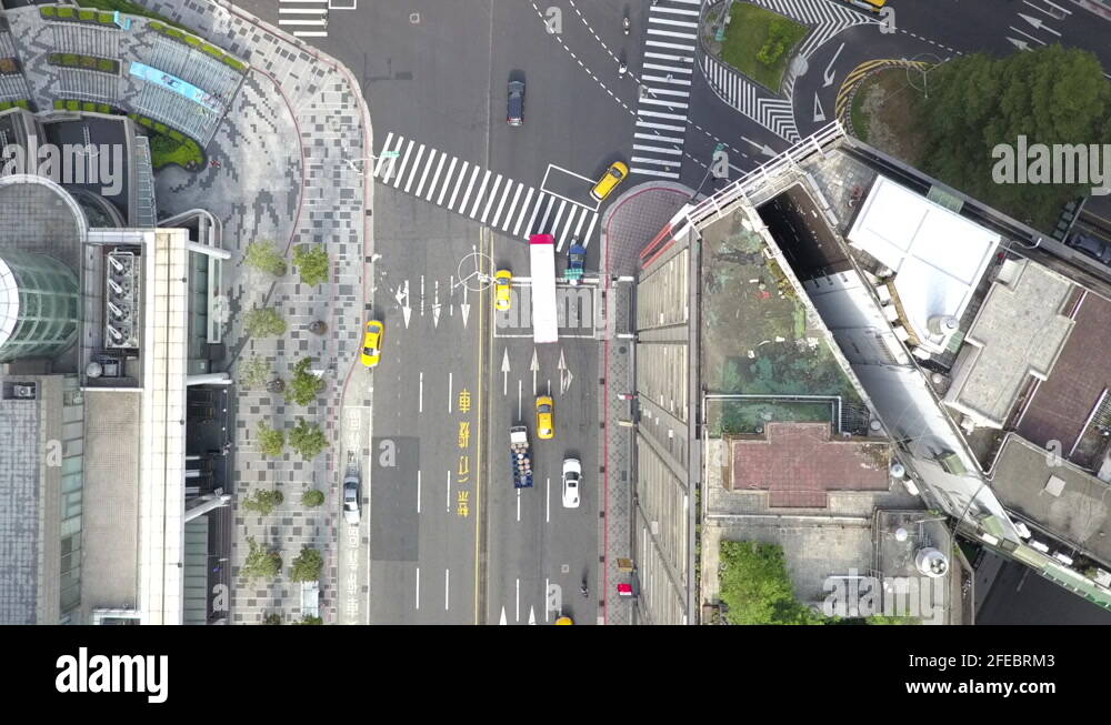 Looking down on a busy city intersection with cars and buses in Taipei ...