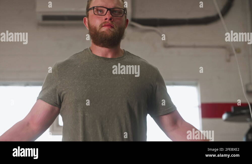Man jumping rope inside of gym in front of window, Slide Right, Pan ...