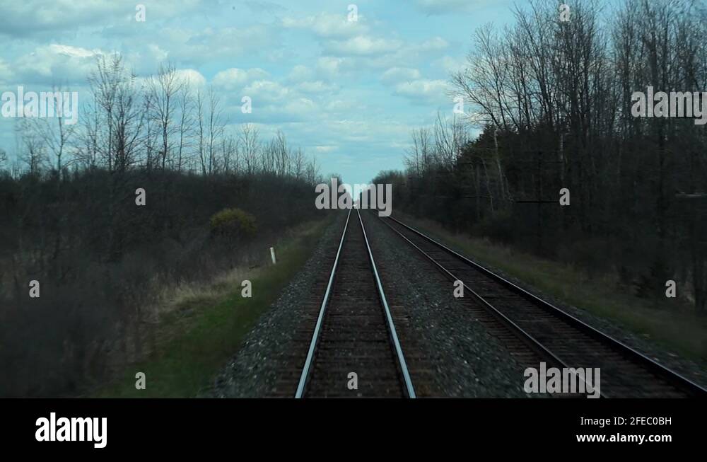 looking outside through the back window of aing train while the rails ...