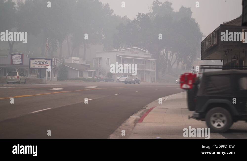 Cars drive down smoke-filled road in small town, creek fire, california ...