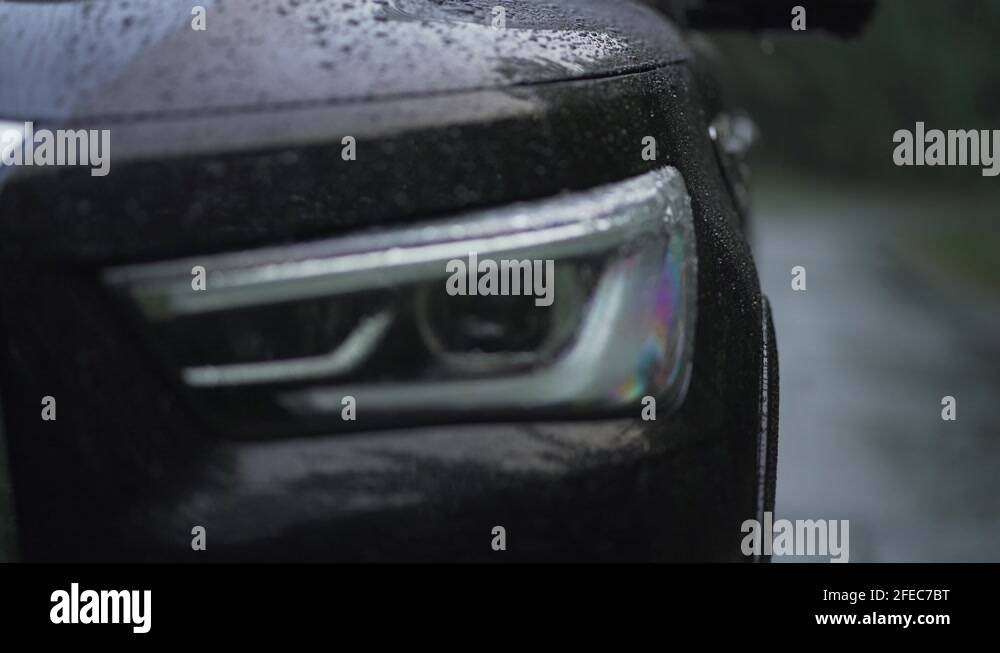 Black High End Car LED Headlight turning on in the Rain as Dew Drops ...