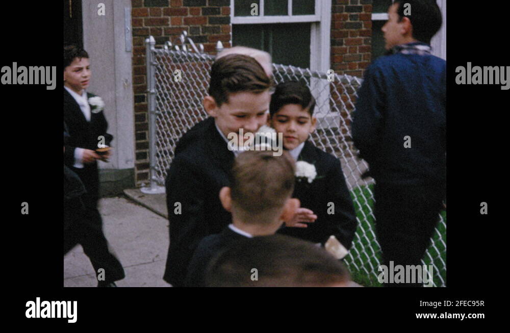 1960s: First communion service ends at church. Boy in suit with corsage ...