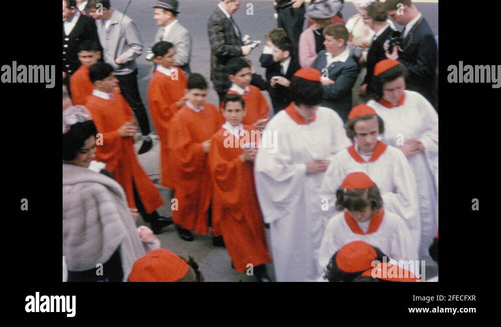 1960s: People watch altar boys walk down sidewalk, into church. Bishop ...