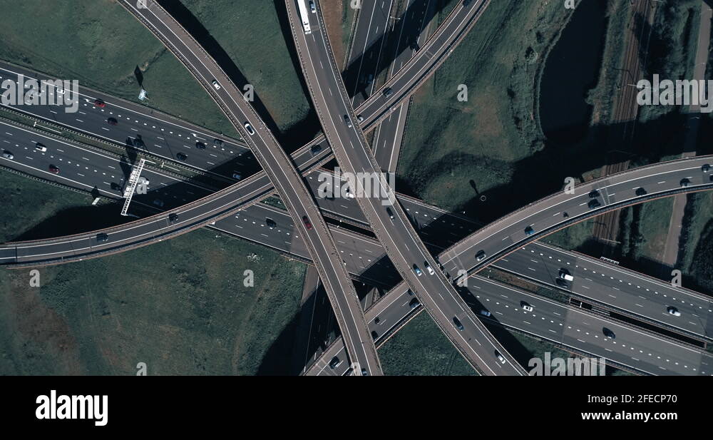 rotating top view aerial of cars travelling over big traffic highway ...