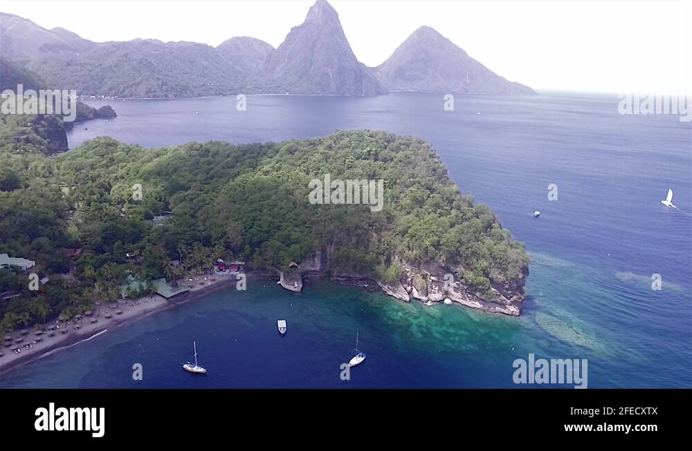Majestic Pitons and Anse chastanet beach, St Lucia, aerial tilt up ...