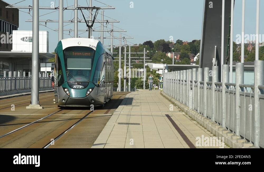 A modern Nottingham tram leave at a stop in Queen's Medical Centre ...