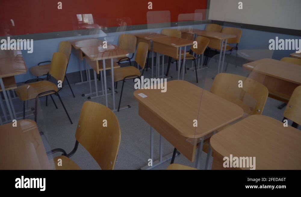 4k video of empty classroom with plastic protection screen on tables ...