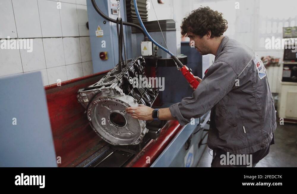 Lifting and installing a car engine in a car workshop at a stand Stock ...