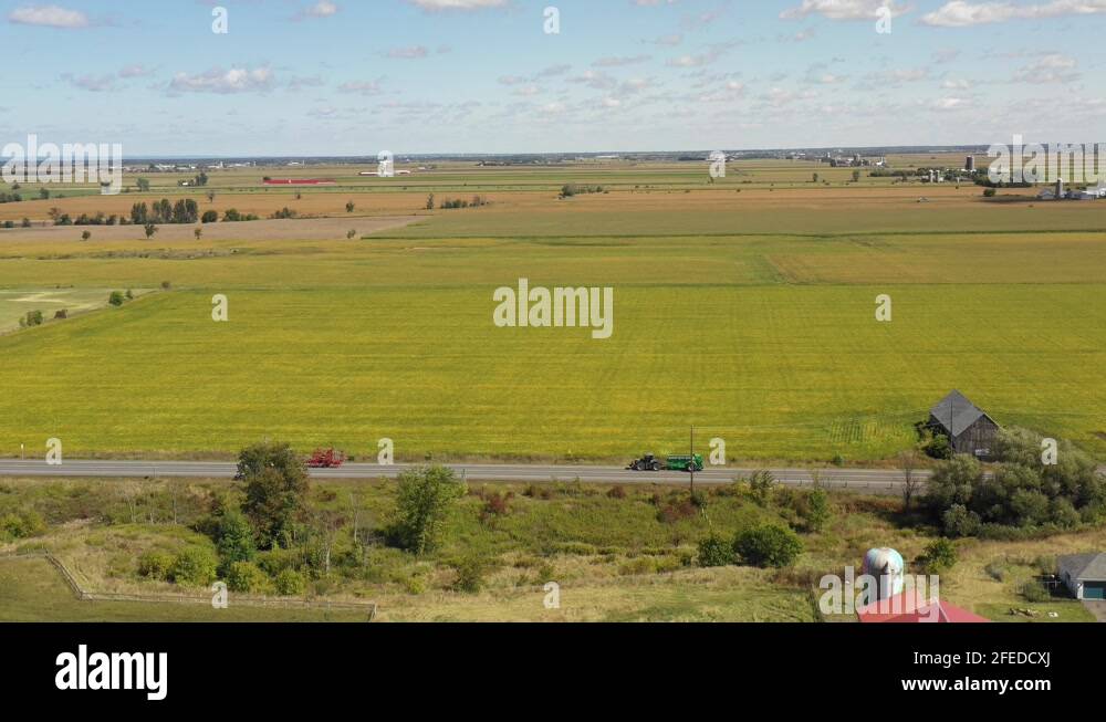 farm tractors pulling equipment down country roads sideways flight ...